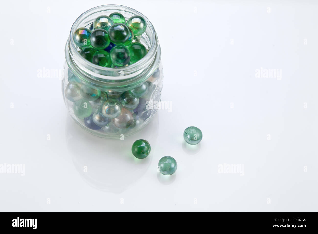 group of marbles in a variety of colors isolated on a white background ...