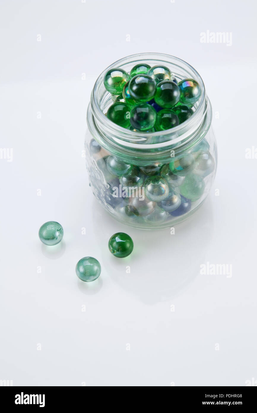 group of marbles in a variety of colors isolated on a white background ...