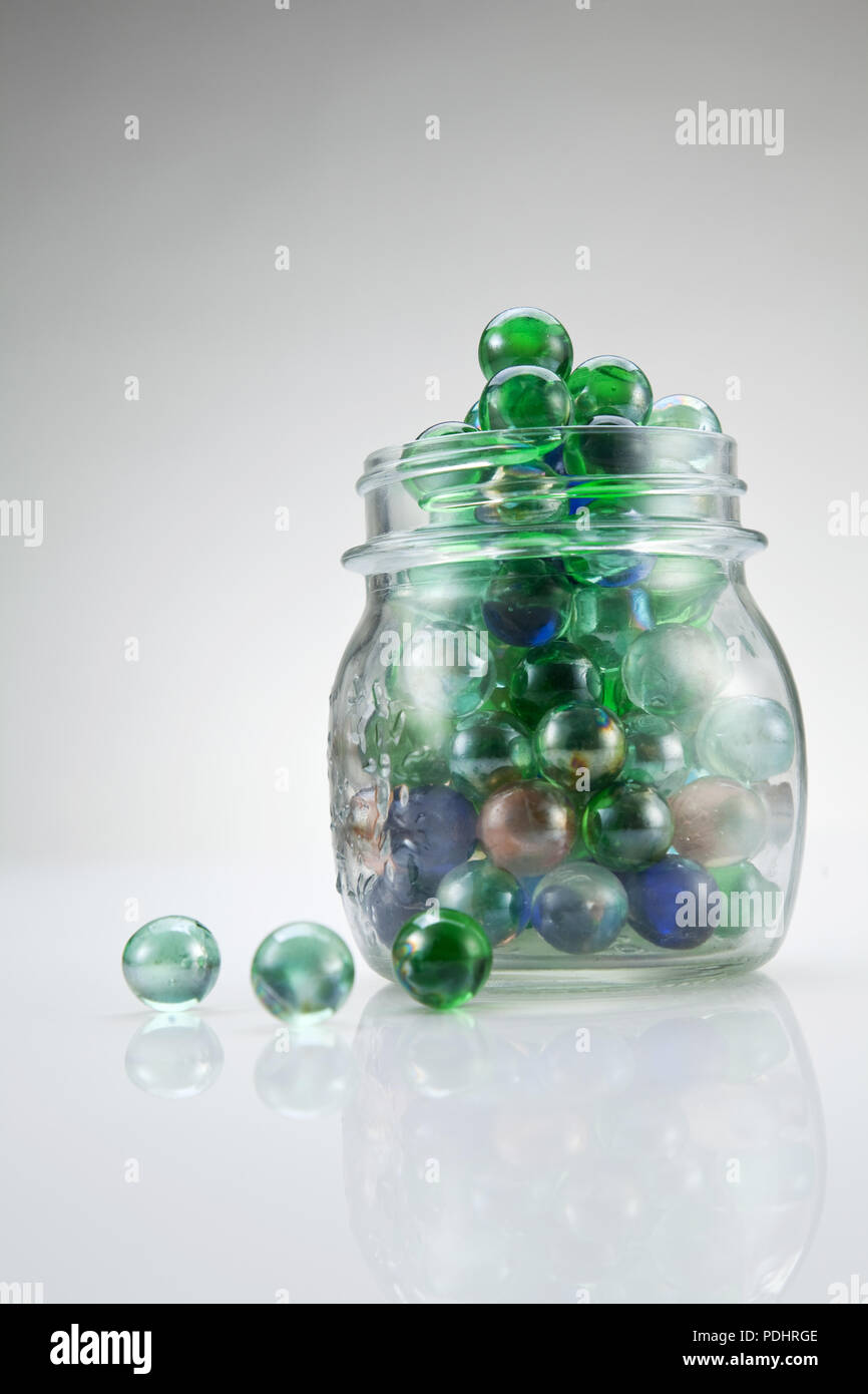 group of marbles in a variety of colors isolated on a white background ...