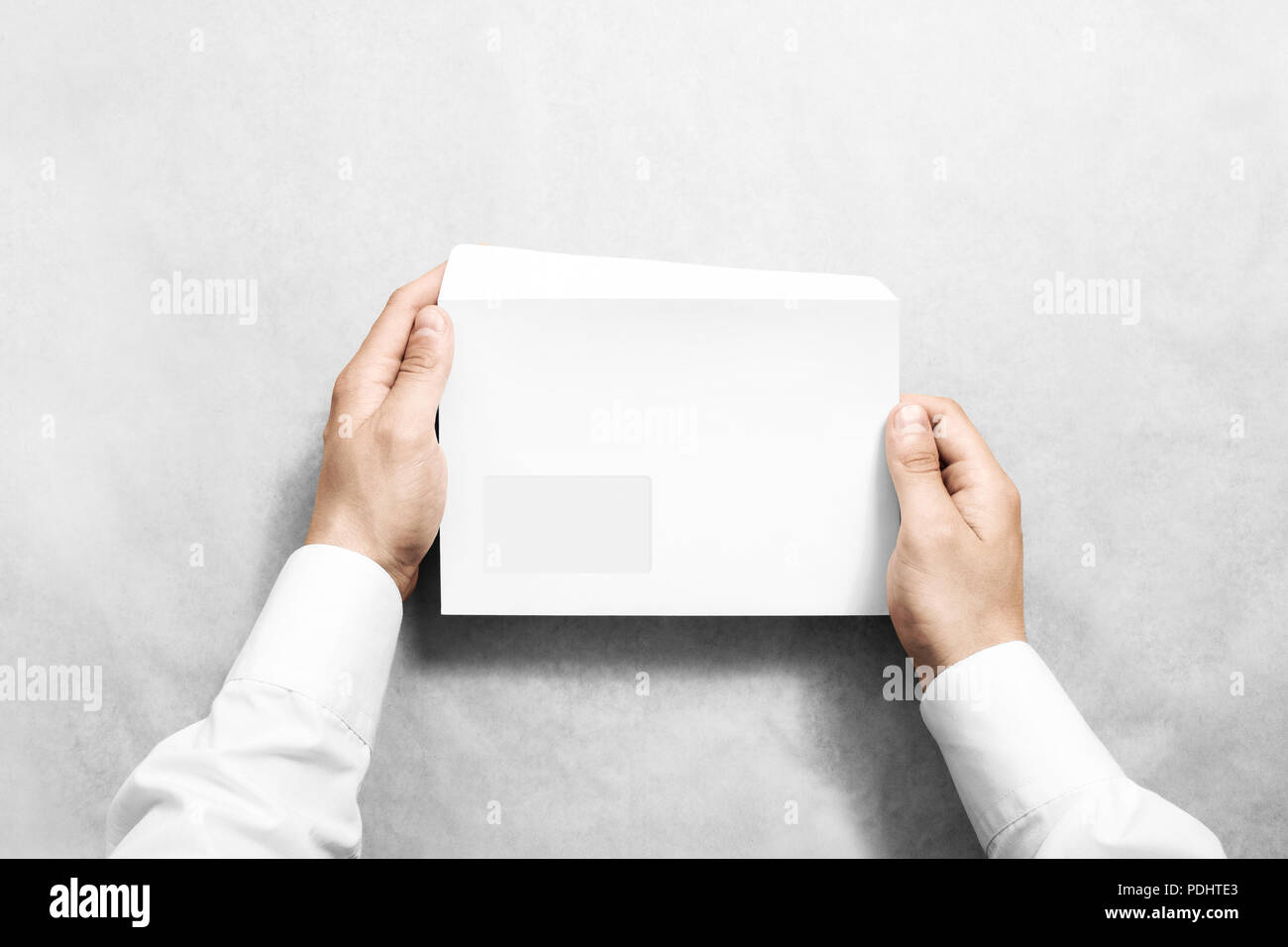 White blank envelope mock up holding in hand. Empty letter with ...