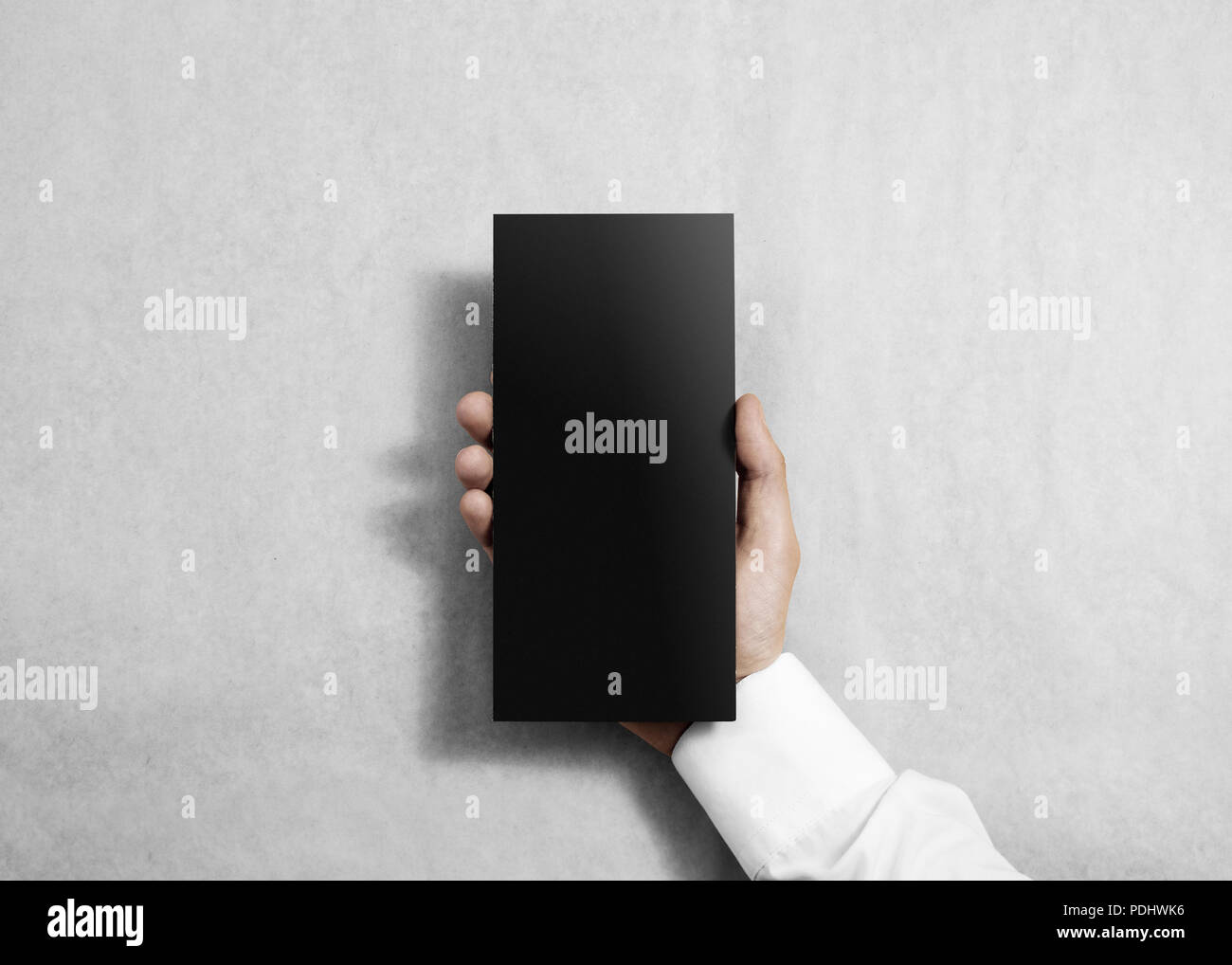 Hand holding blank black flyer brochure booklet in the hand. Leaflet ...