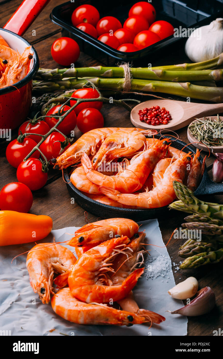 Top view of rustic wooden table full of prawns and some ingredients for ...