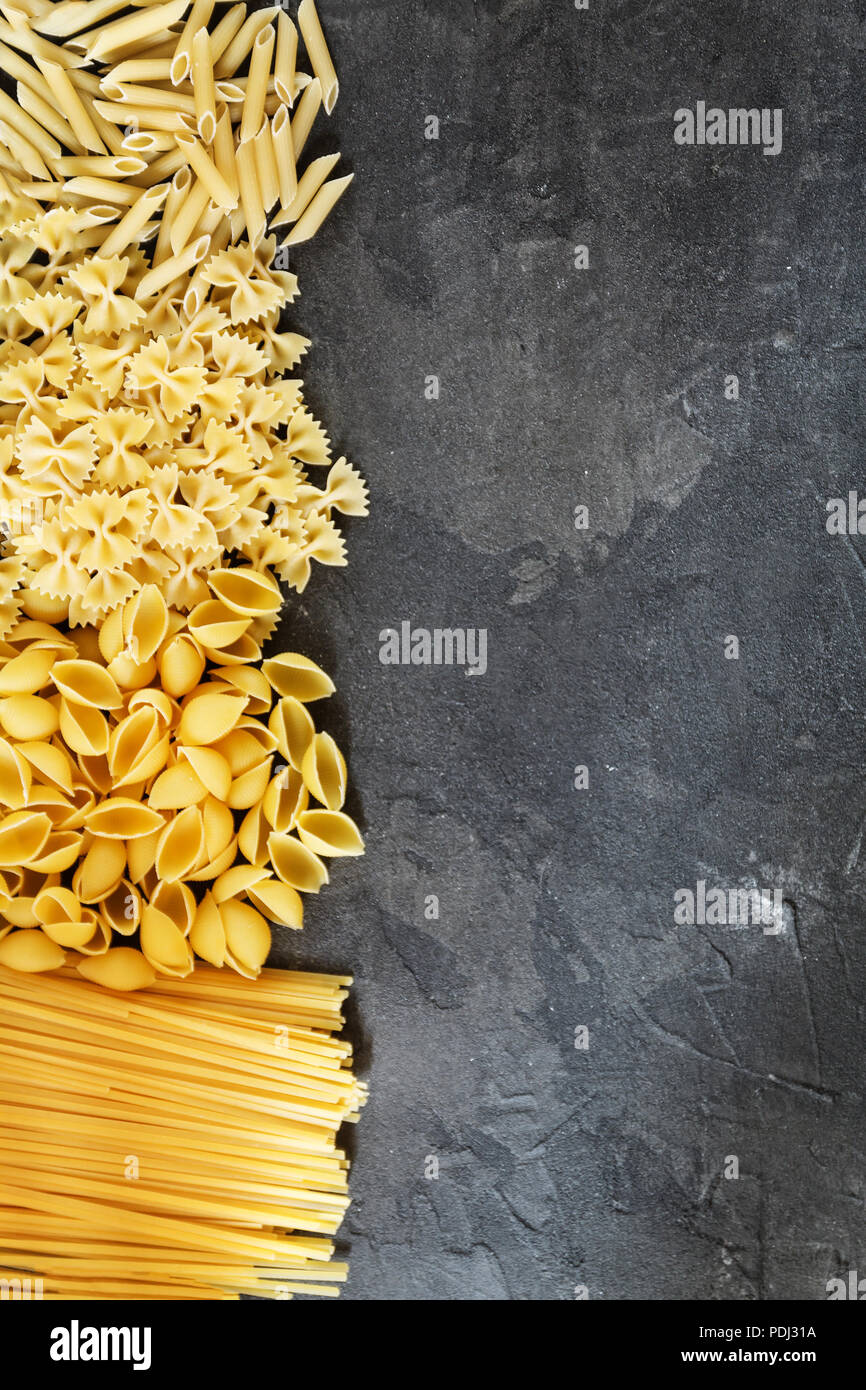 Dry pasta background. Different pasta on dark background. Flat lay. Top ...