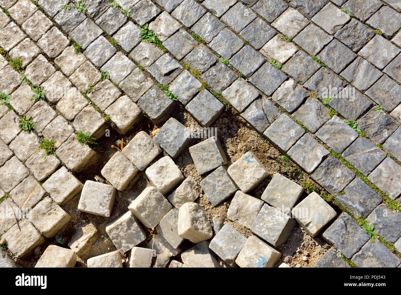 Stone paving with some of the granite setts lose Stock Photo - Alamy