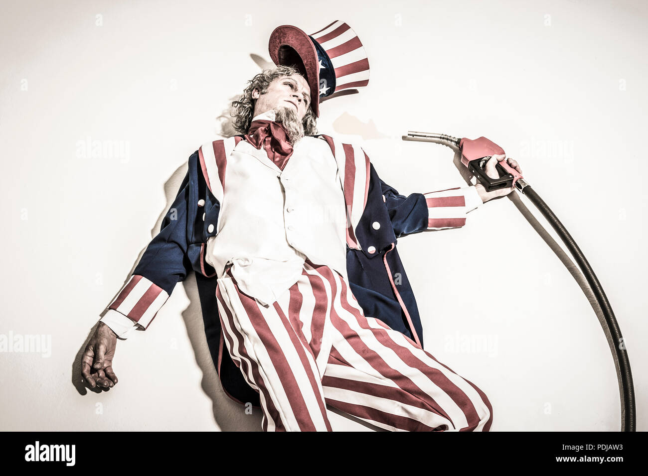 Uncle Sam lying dead next to a gasoline pump nozzle. Addicted to oil ...