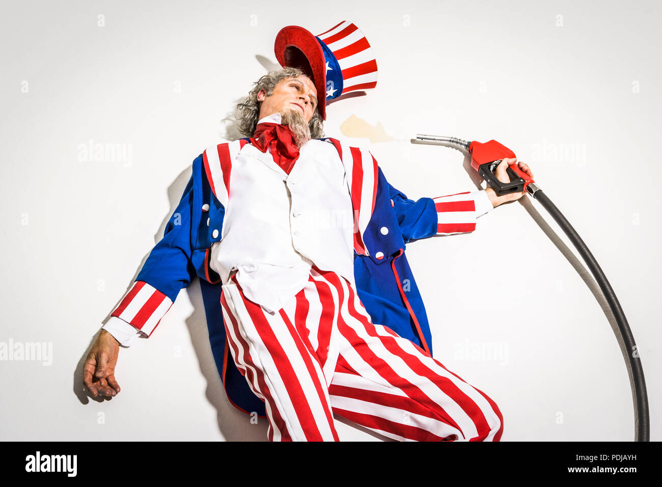 Uncle Sam lying dead next to a gasoline pump nozzle. Addicted to oil / fossil fuels Stock Photo ...
