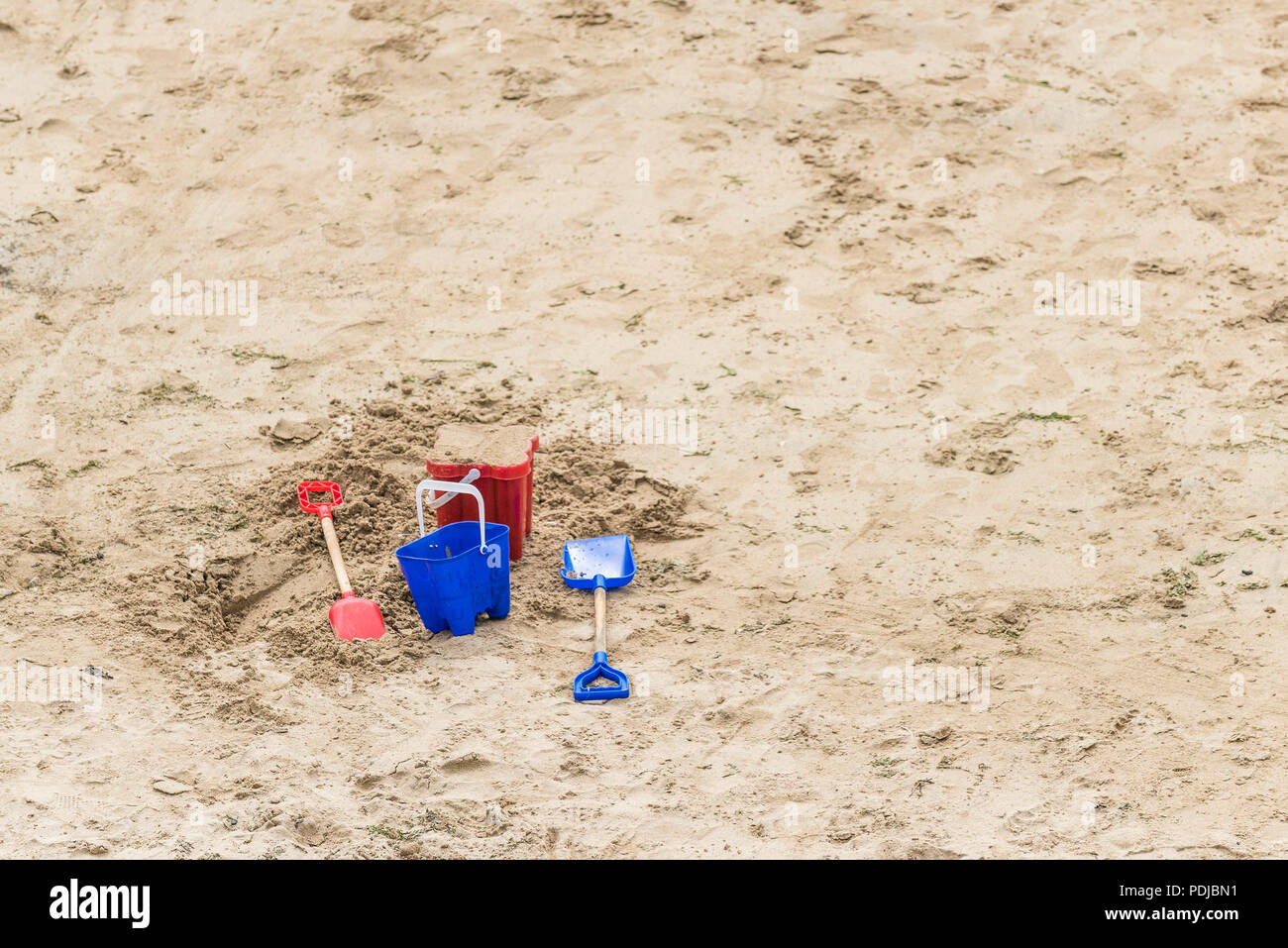 Colourful plastic buckets and spades on a sandy beach Stock Photo - Alamy