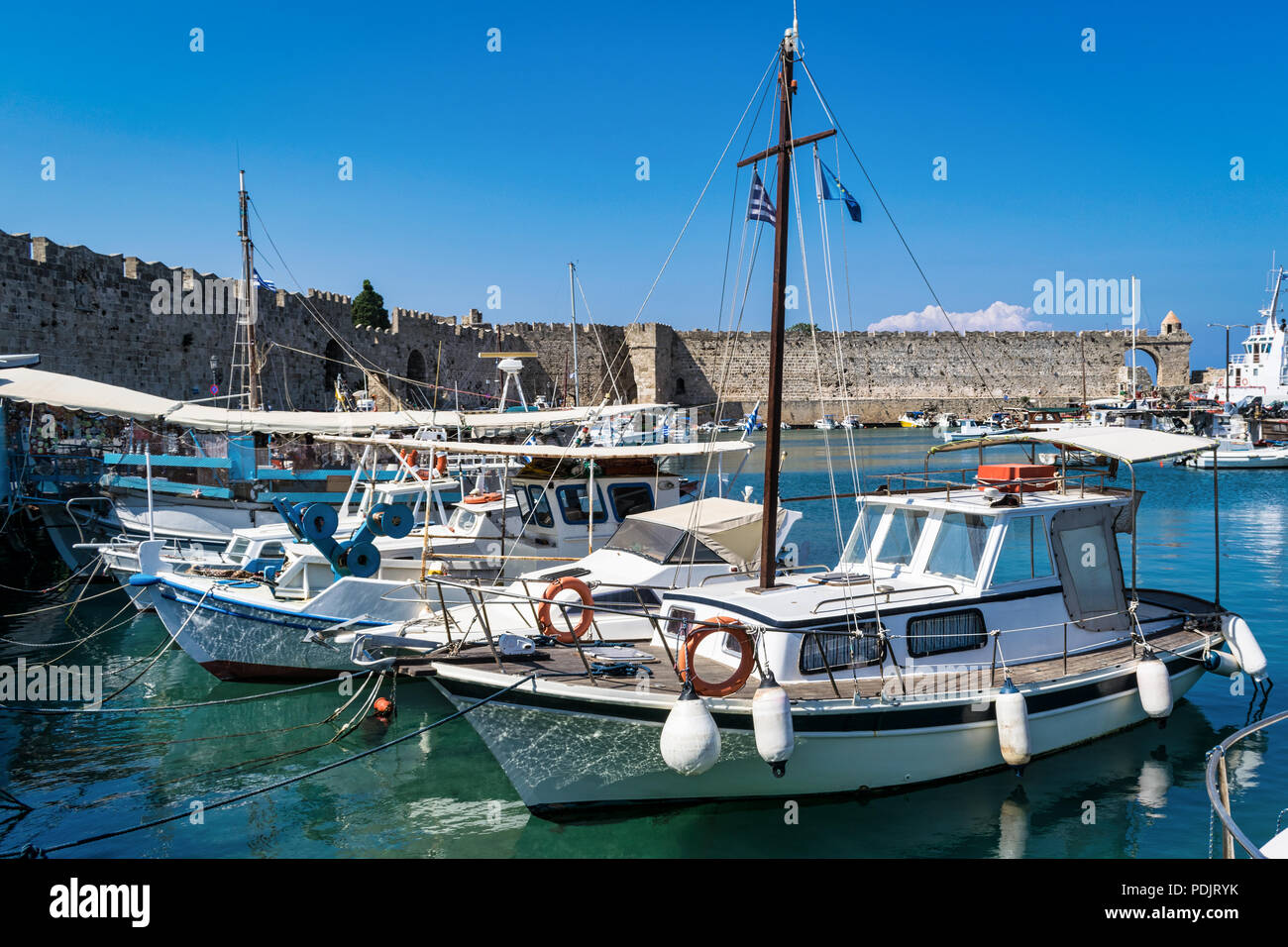 This is a picture of several fishing boats moored in Rhodes harbour in ...
