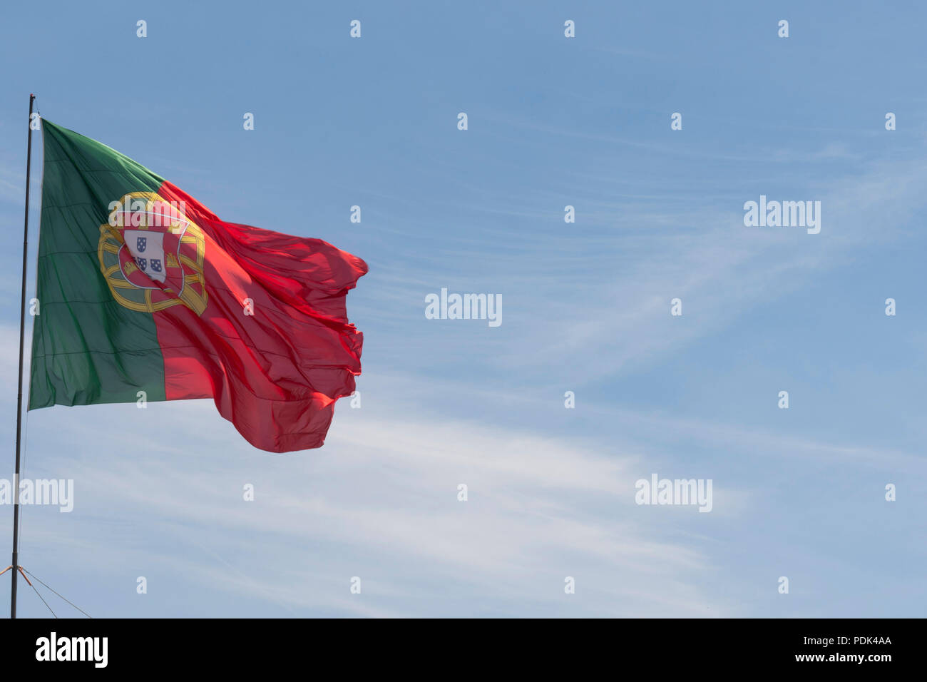 Portuguese flag waving in front of blue sky Stock Photo - Alamy