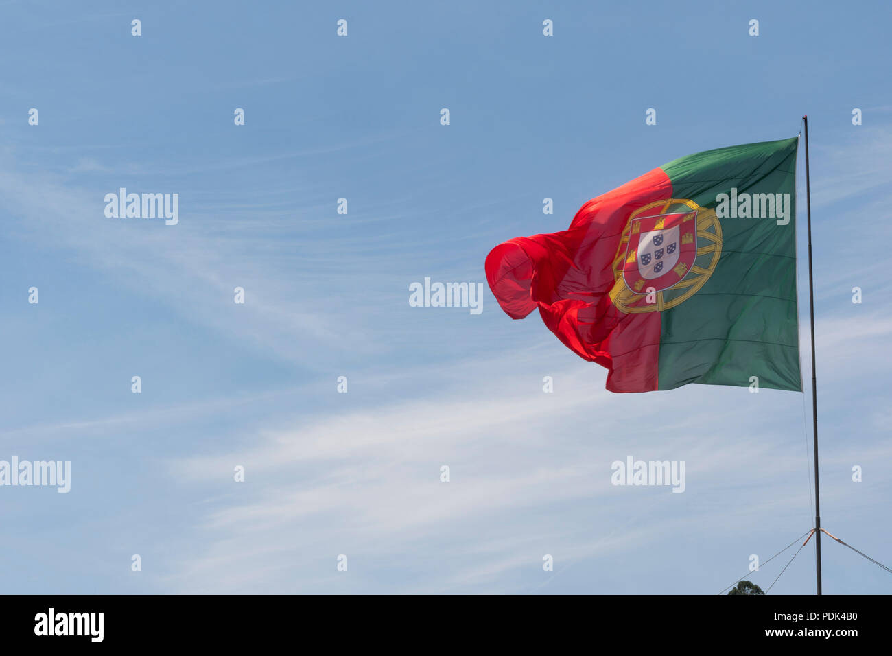 Portuguese flag waving in front of blue sky Stock Photo - Alamy