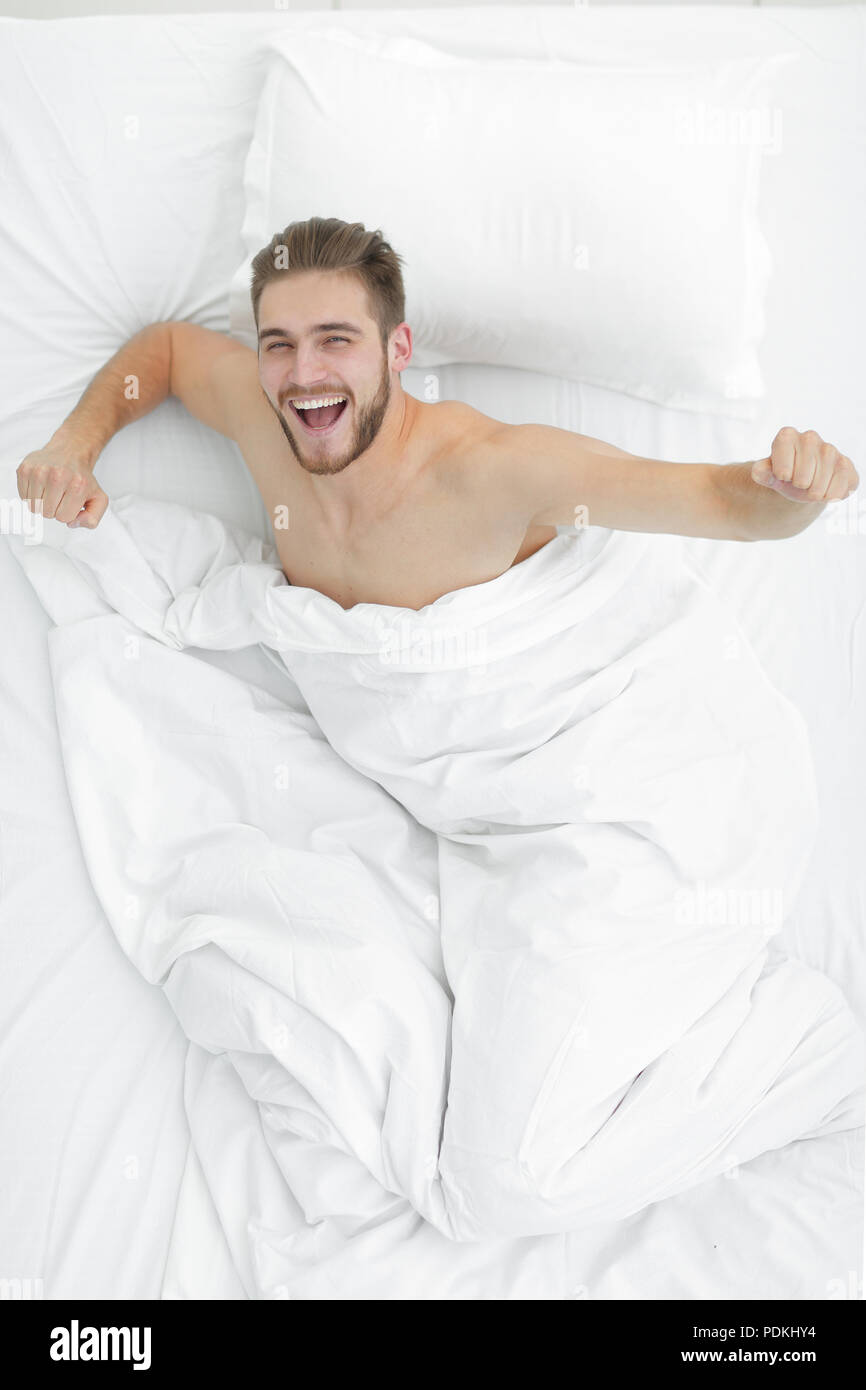 top view. happy man waking up in a comfortable bed Stock Photo - Alamy
