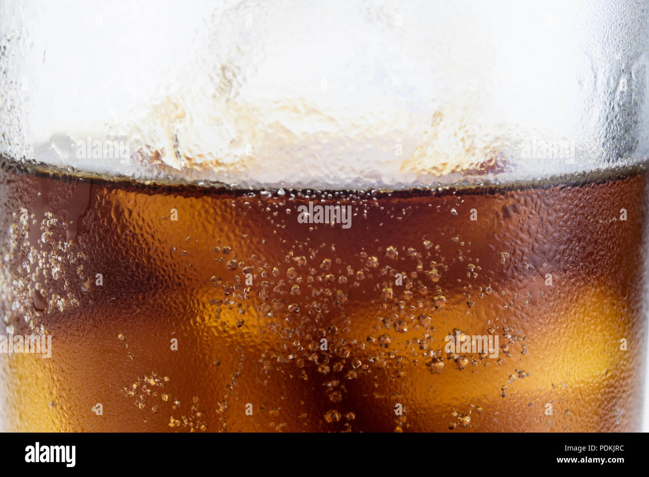 Cold drink with ice in a glass on a white table. A way to cool down on ...