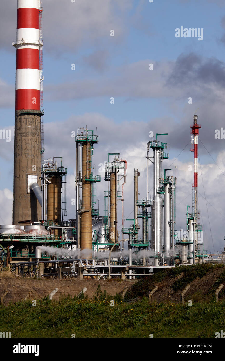 Industrial pipes and chimneys from a big oil refinery seeing steam and ...
