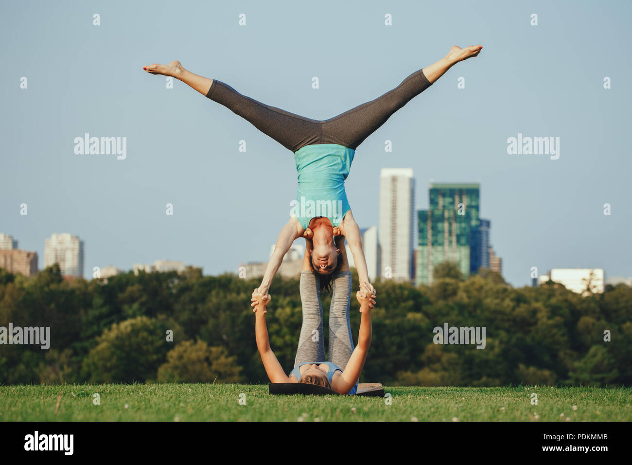 Two young beautiful Caucasian women yogi doing star acro yoga pose ...