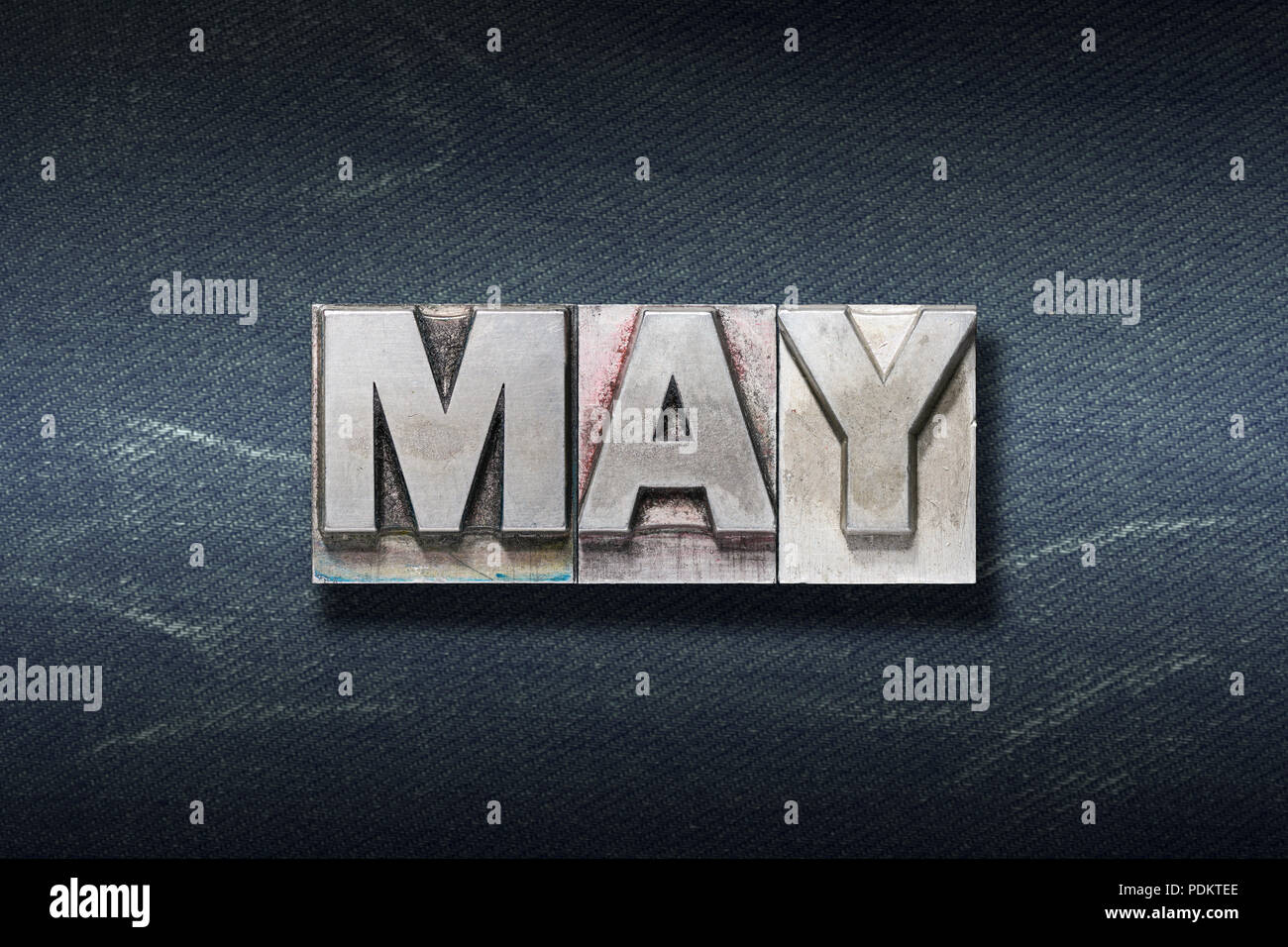 May word made from metallic letterpress on dark jeans background Stock ...