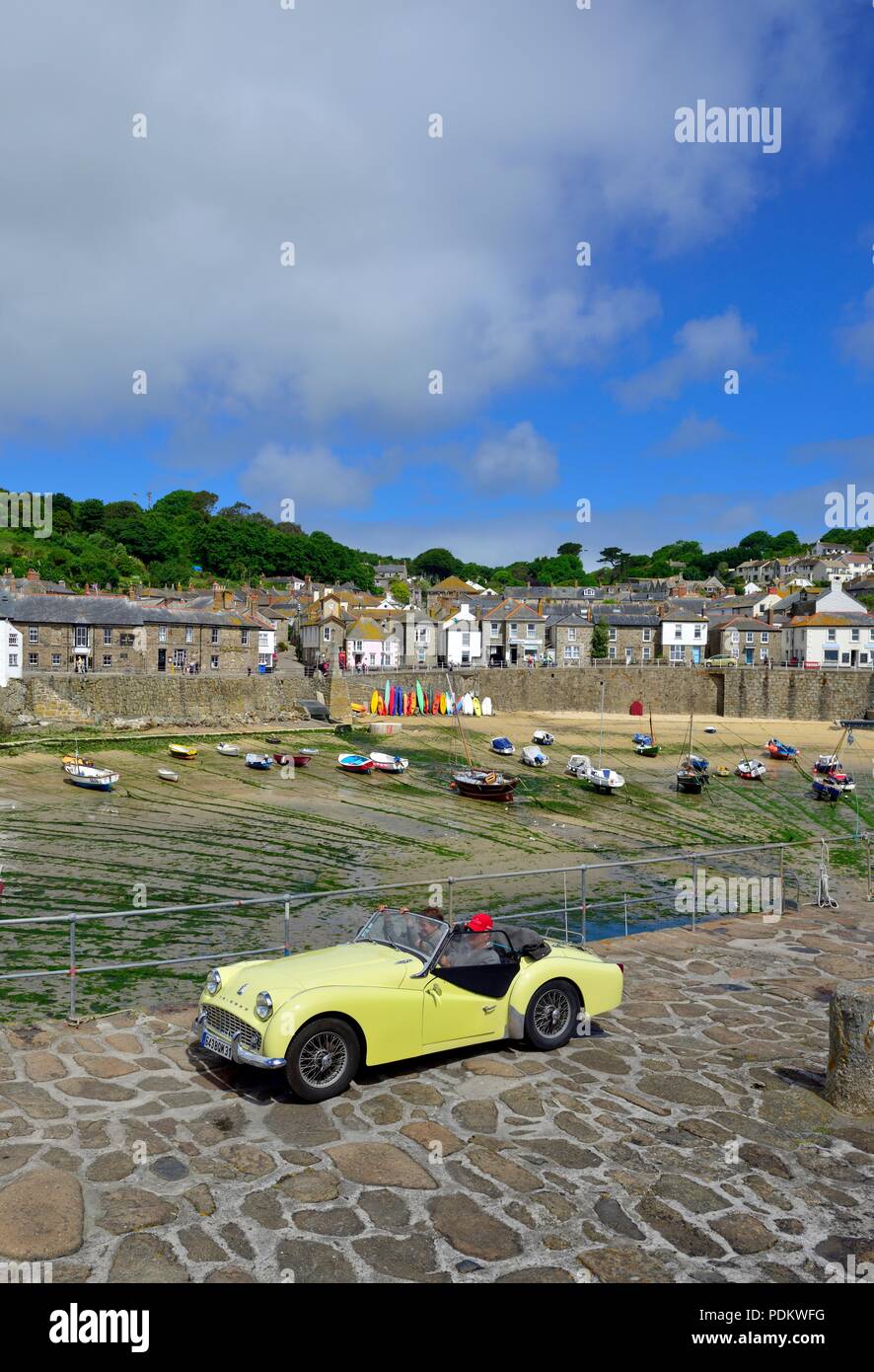 Yellow Triumph TR3 leaving harbour car park in,Mousehole,Cornwall ...