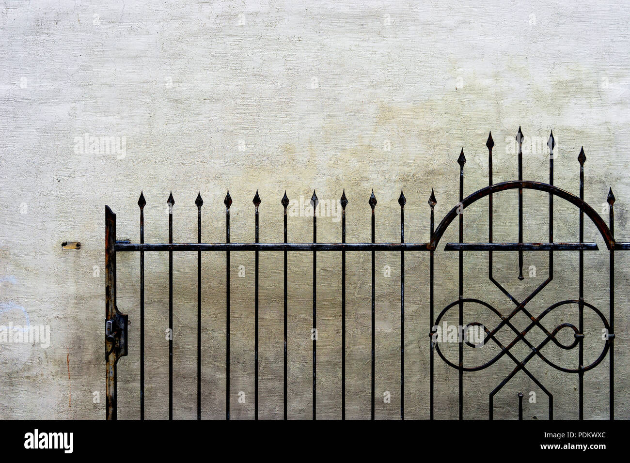 Sharp items like spears metal gate on the background of the old wall ...