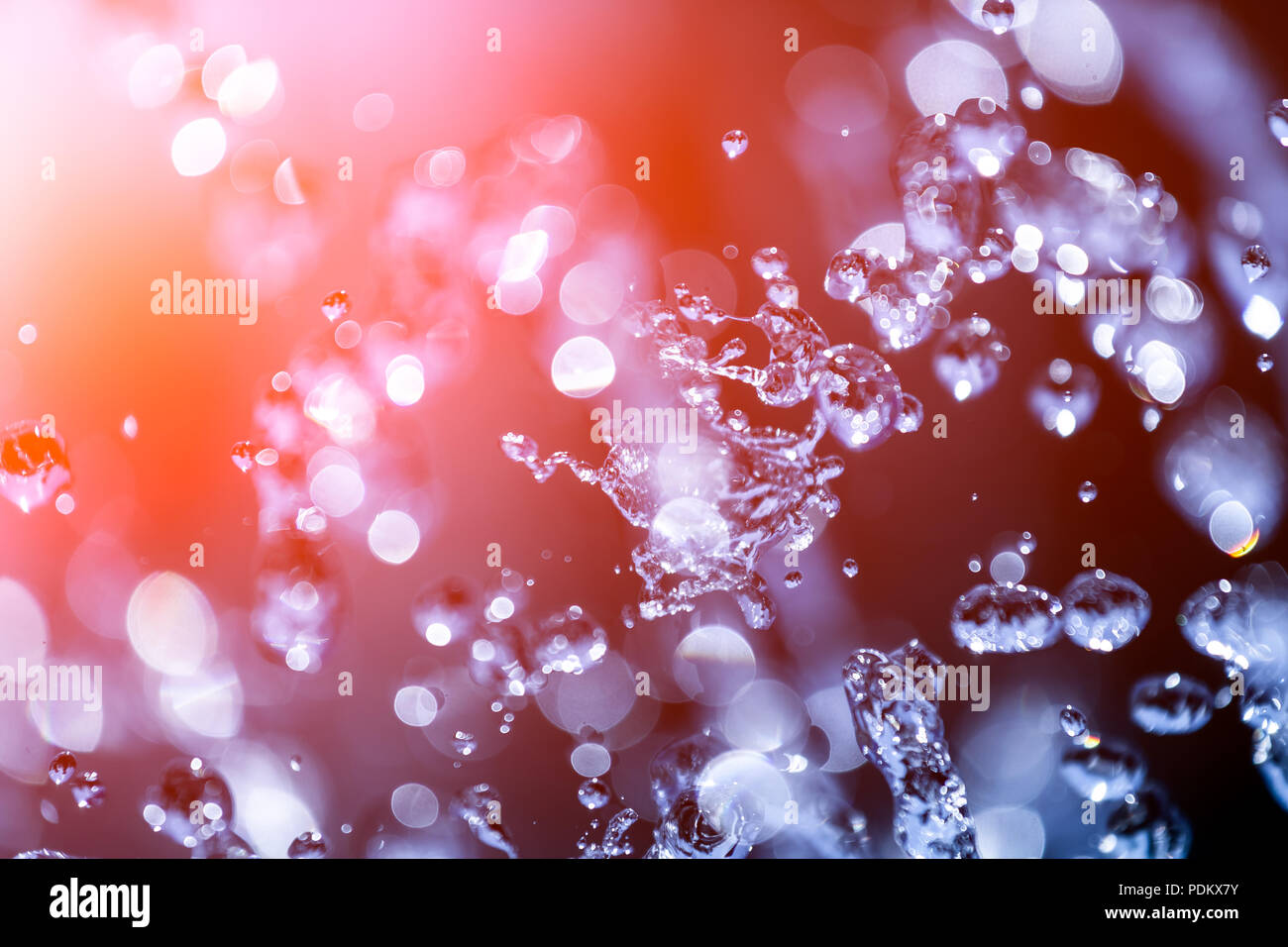Close up of a water drops on a red, yaellow and blue gradient ...