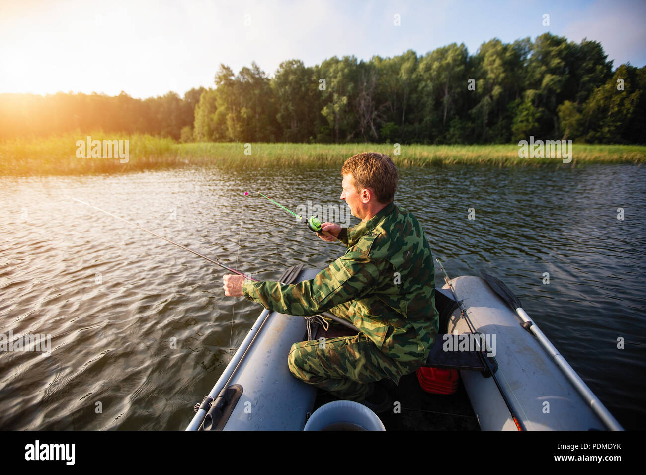 Fisherman catching fish on the river from rubber boat Stock Photo - Alamy