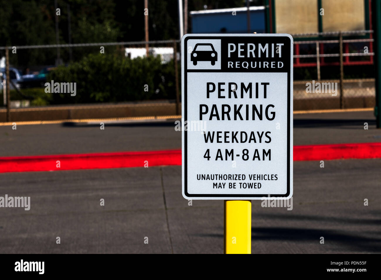 Permit parking street sign with a car symbol in front of a red stripe ...