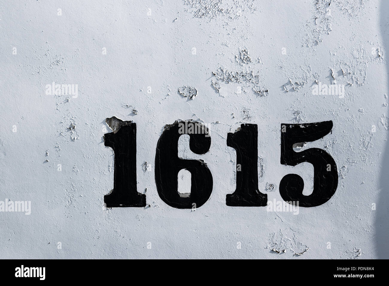 Street numbers 1615 on white chipped faded worn paint on a wall Stock ...