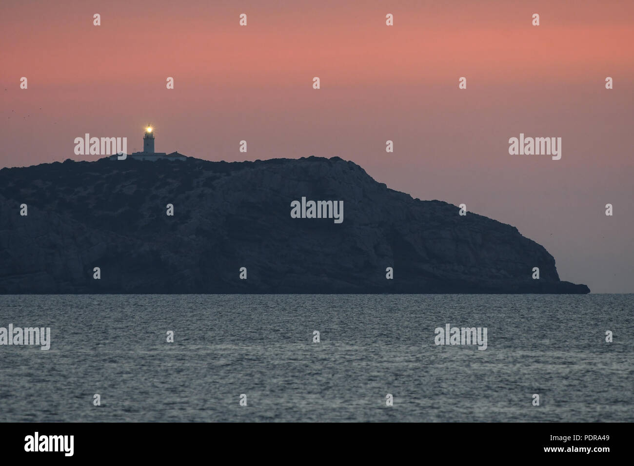 Sunset over the lighthouse in Ibiza Stock Photo - Alamy