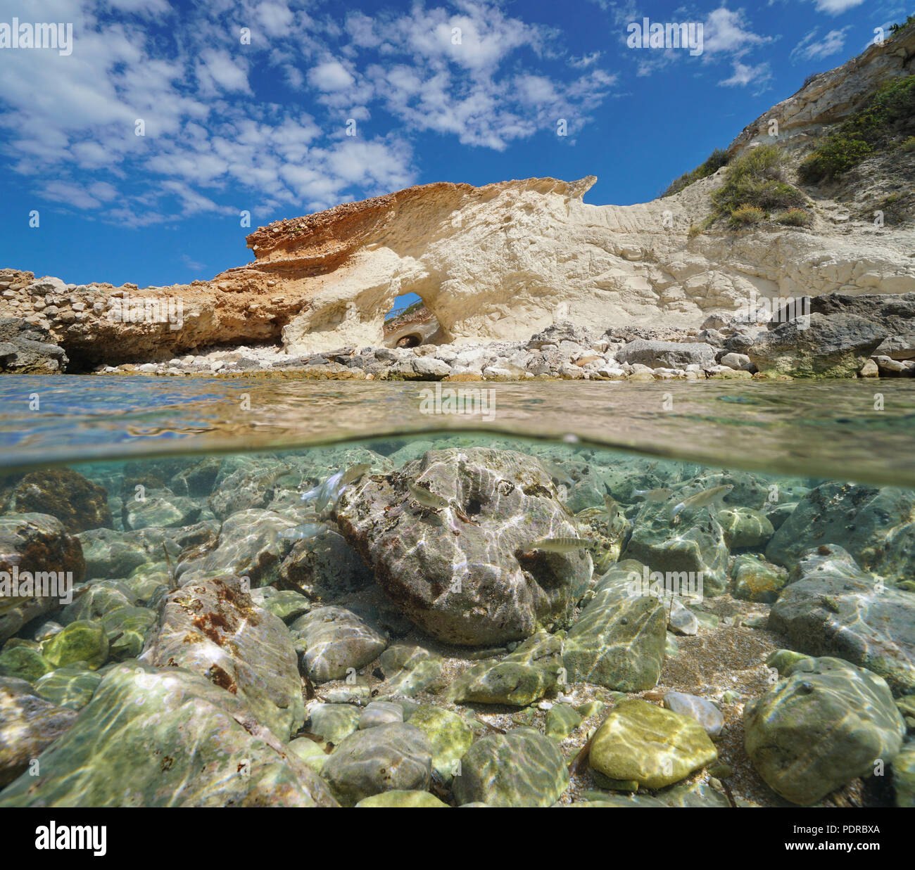 Rock formation on the seashore with fish and rocks underwater, split ...