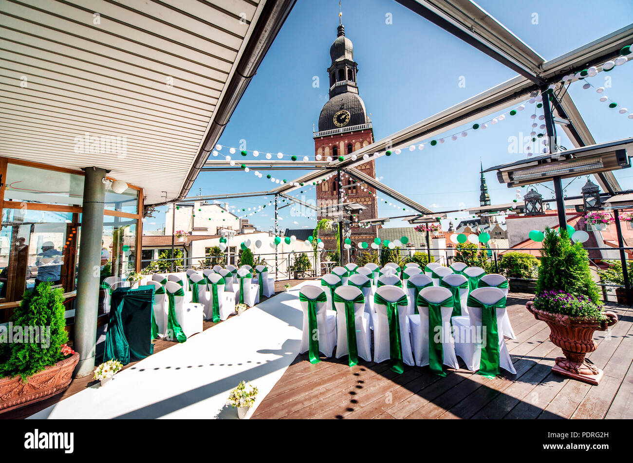 White chairs with green ribbon on a terrace is ready for a wedding ...