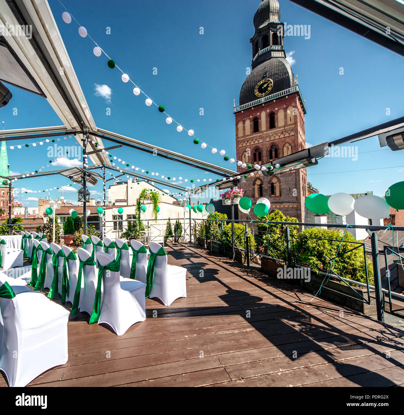 White chairs with green ribbon on a terrace is ready for a wedding ...