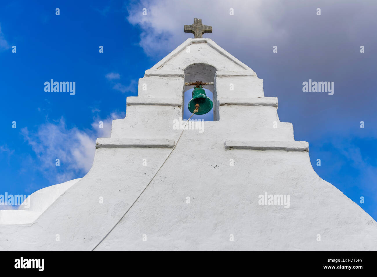 Bell tower at a Greek island against blue sky background.Green bell ...