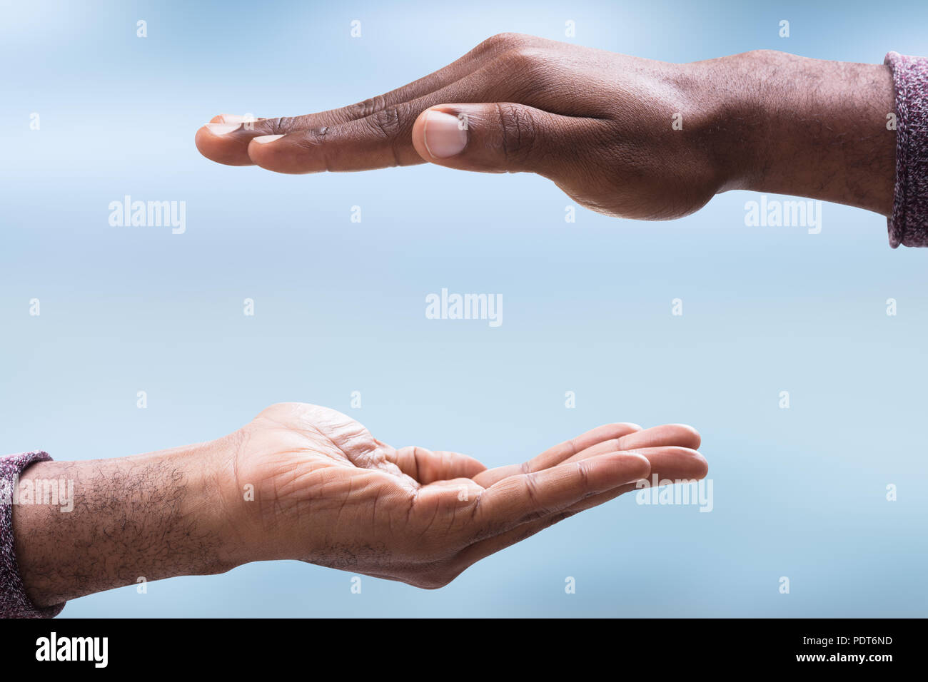 Close-up Of Male's Two Hand Against Blue Background Stock Photo - Alamy