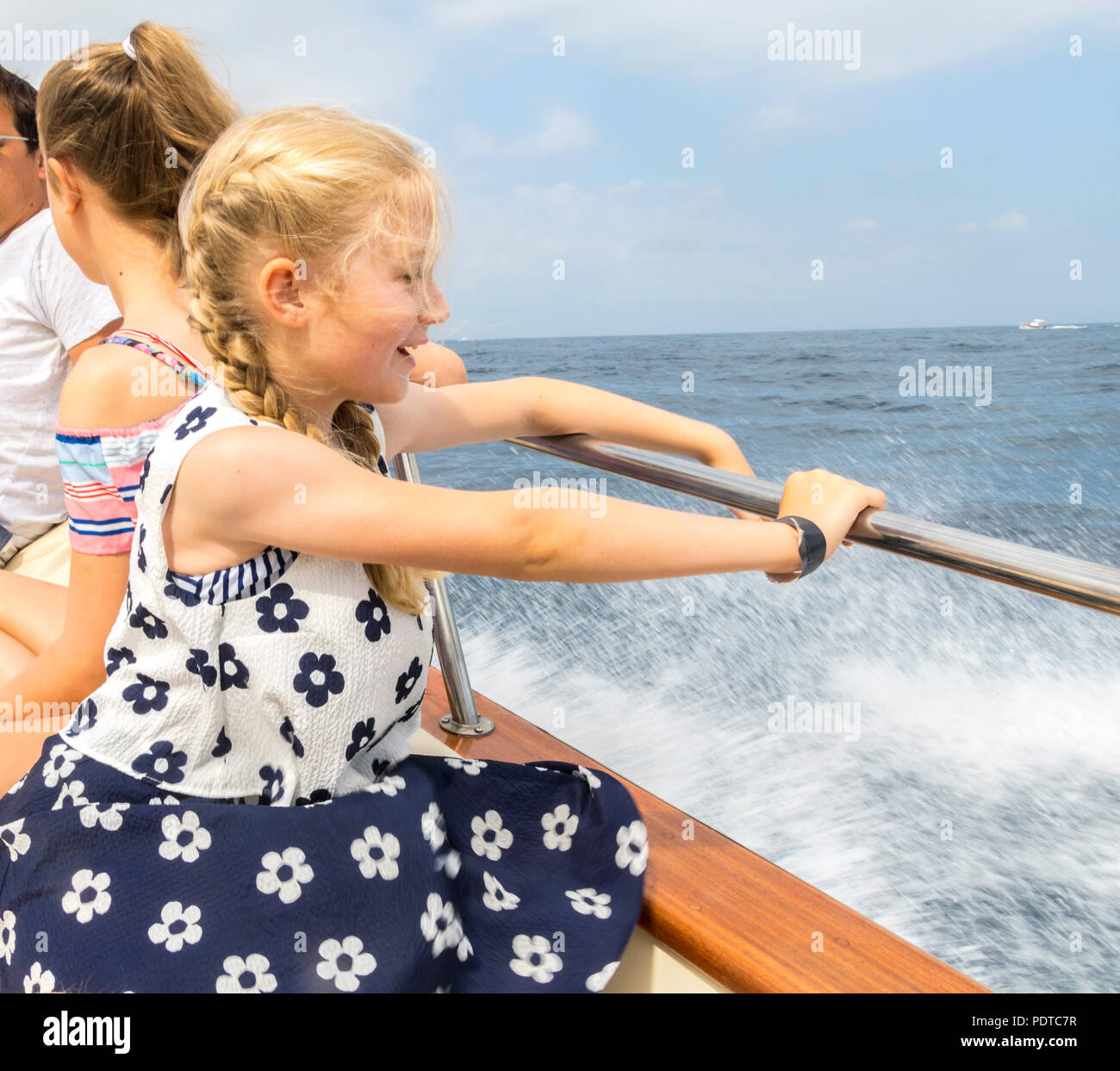 Excited, happy Girl, kid, child, sitting on a yacht, cruise boat ...