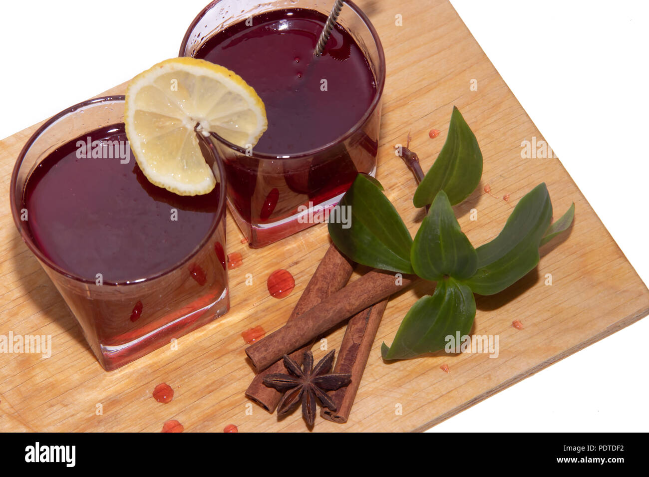 Syrup of red currant in glasses on a wooden board on a white background ...