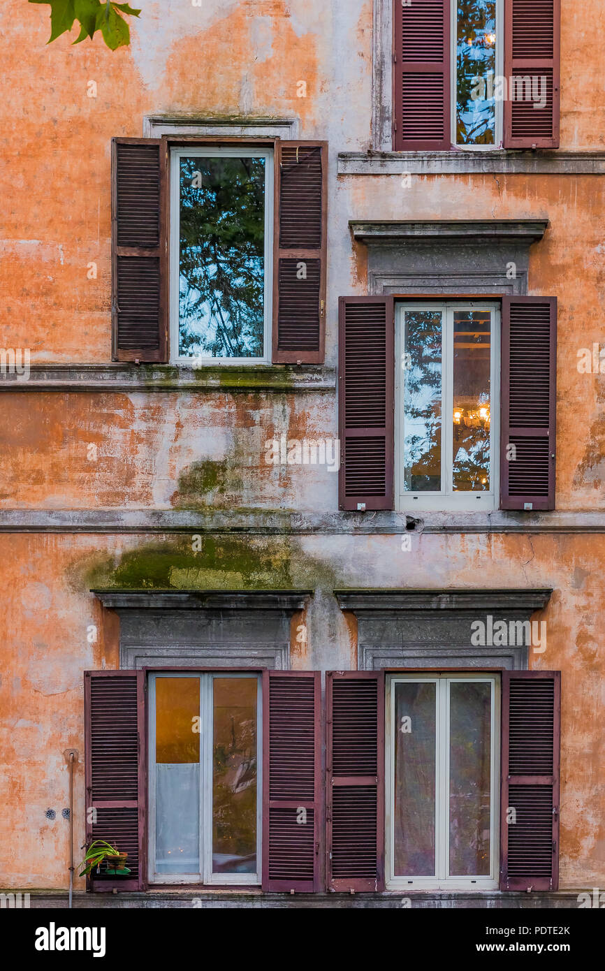 Rows of old windows with shutters on an apartment building in Rome ...