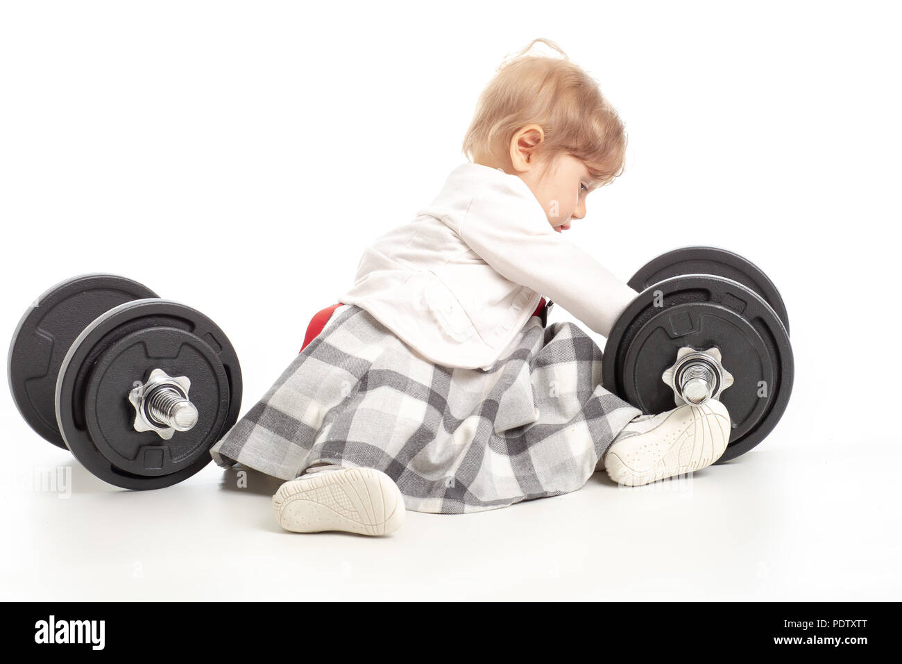 Small female baby playing with gym weights in studio shot on white ...