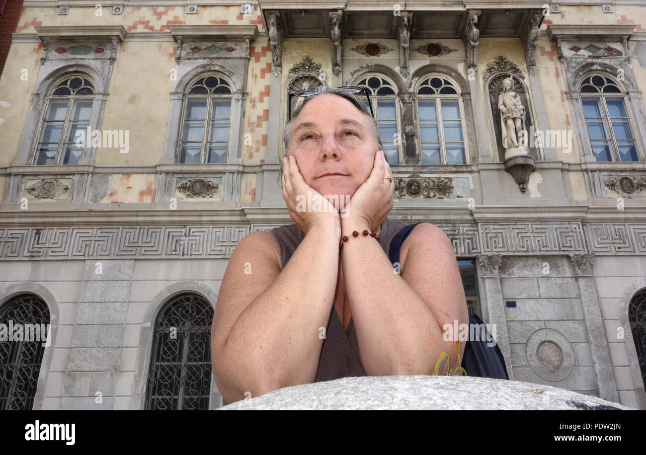Mature Woman posing in front of a traditional building exterior in ...