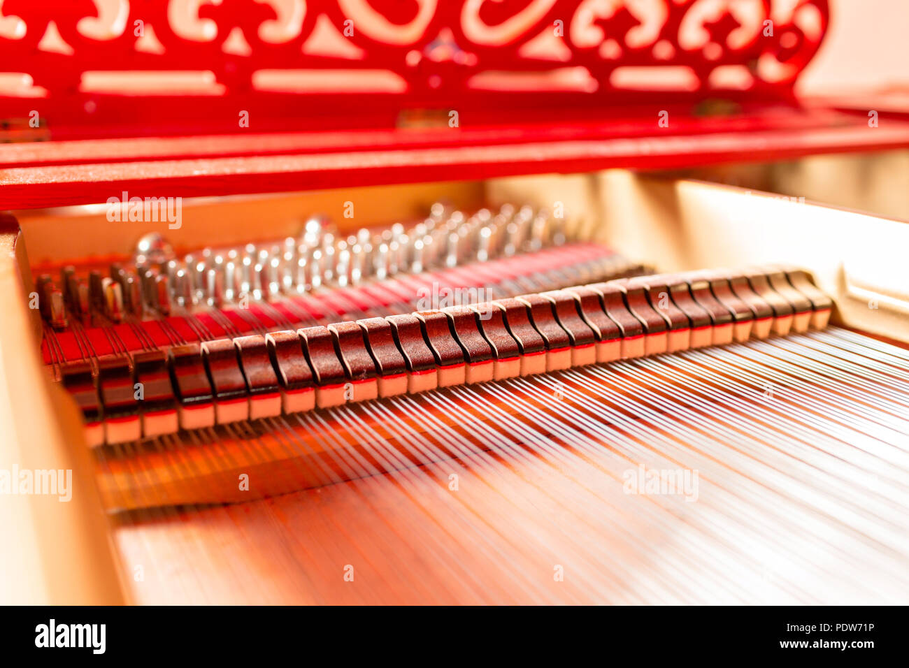 Strings inside a red grand piano. Piano playing, dampers, felt hammers ...