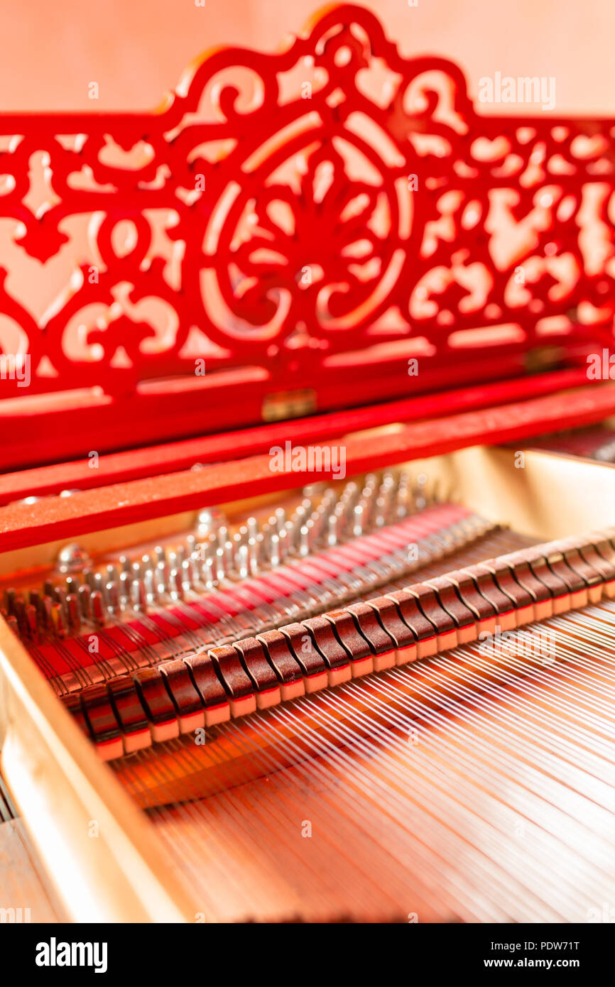 Strings inside a red grand piano. Piano playing, dampers, felt hammers ...