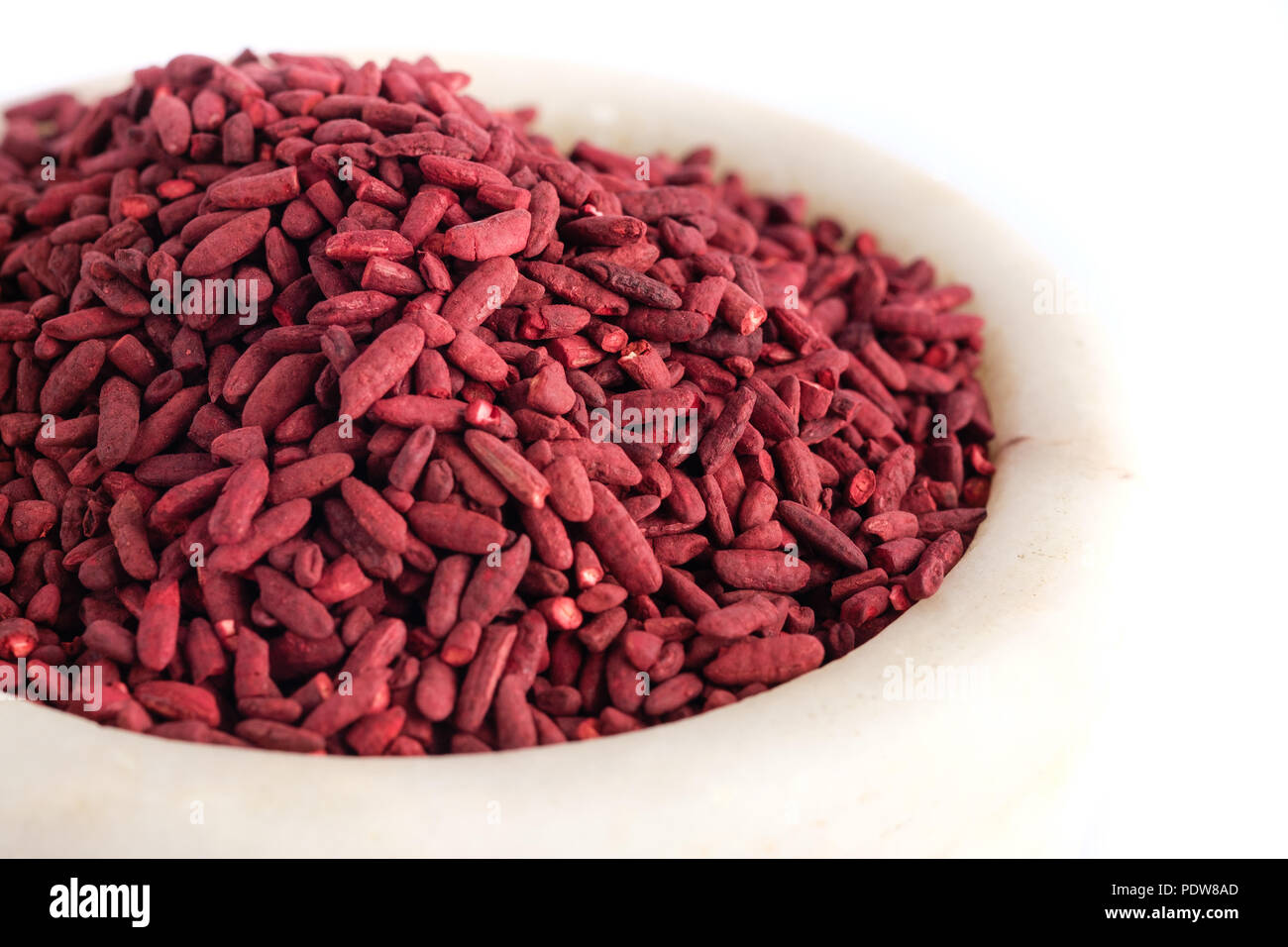 Red yeast fermented rice on white background Stock Photo - Alamy
