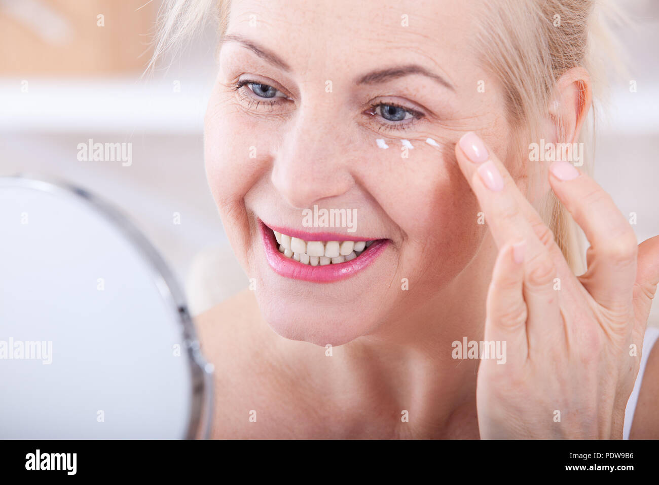 Forty years old woman looking at wrinkles in mirror. Plastic surgery ...