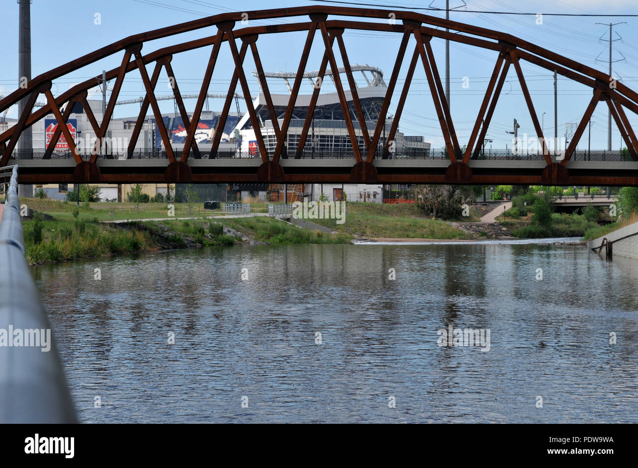 Invesco Field seen through a bridge crossing the South Platte River ...
