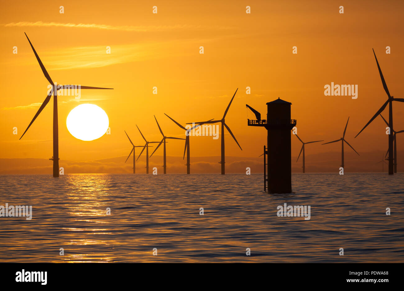 Wind turbines of Walney Offshore Wind Farm in the Irish Sea at sunrise ...