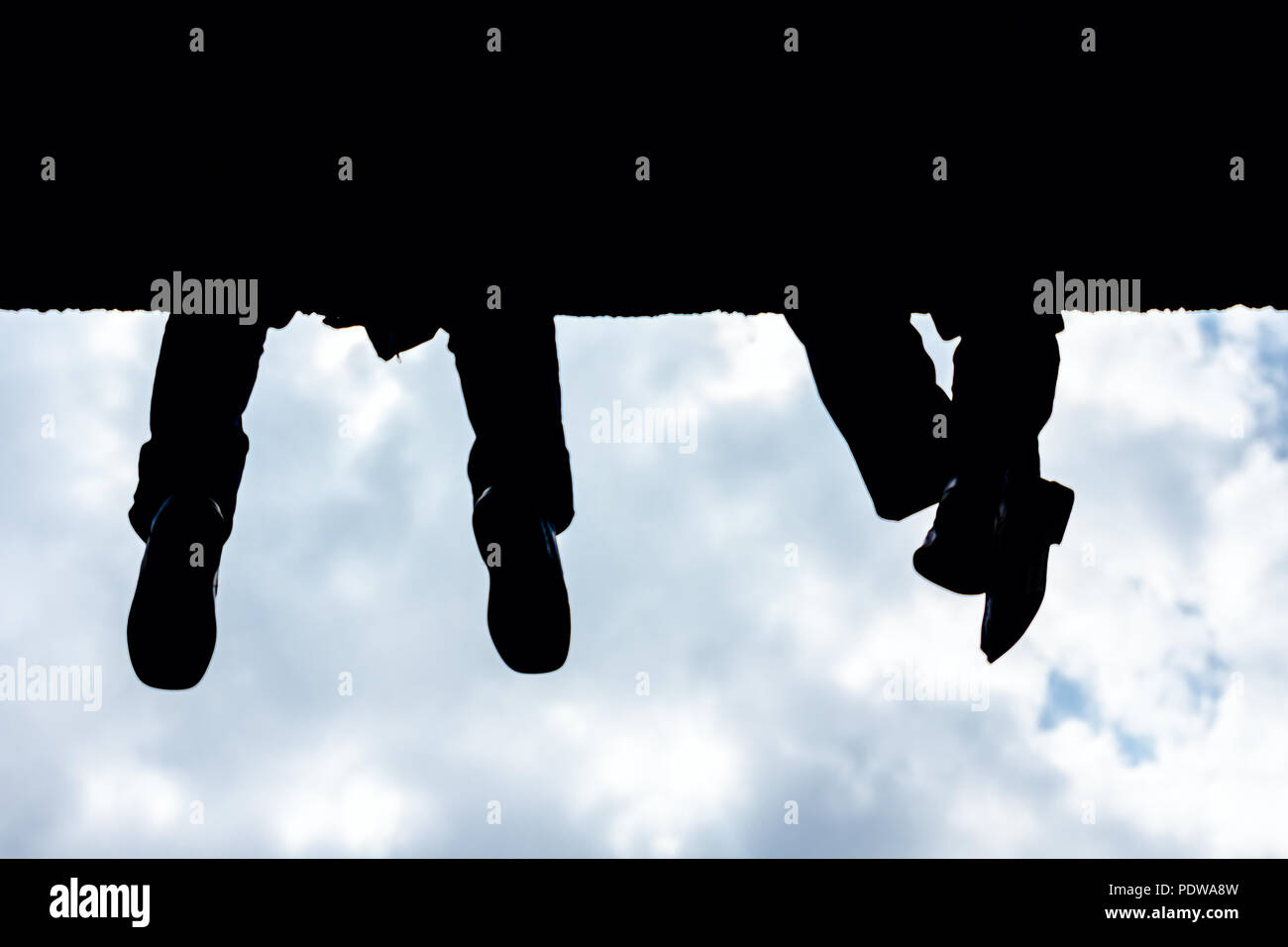 Silhouette, shadows of people's legs hanging from grandstand, view ...
