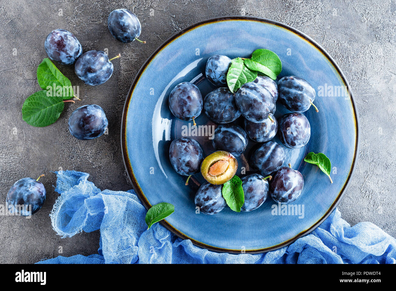 Fresh juicy sweet plums on plate with leaves Stock Photo - Alamy