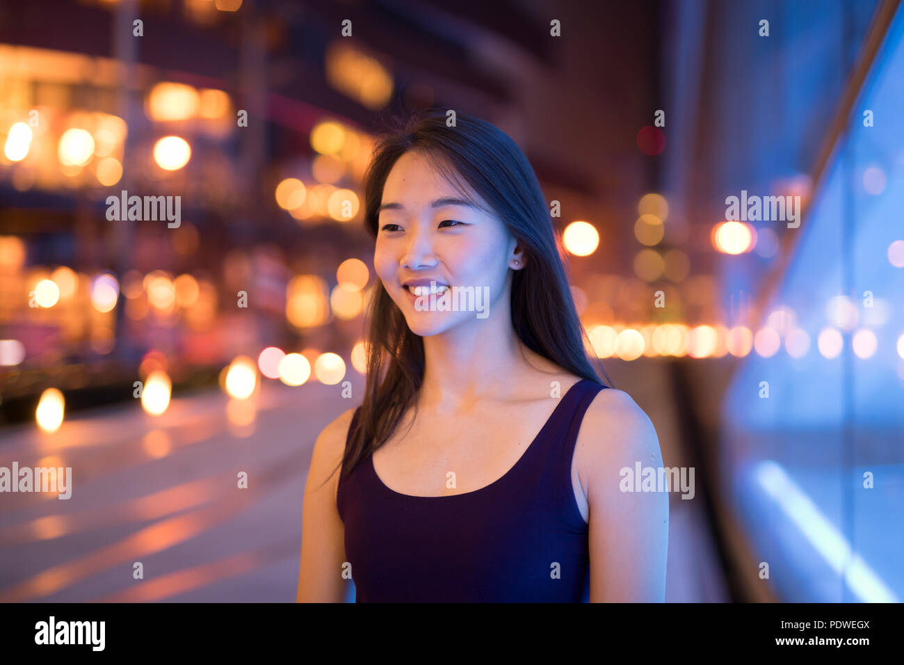 Happy Asian Woman Thinking Outdoors At Night Stock Photo - Alamy