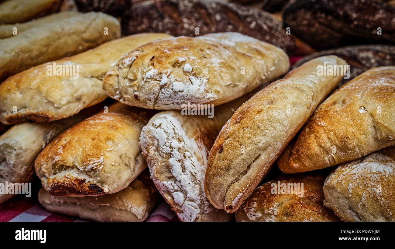 A stack of fresh bread sitting on a table at an outdoor market Stock ...
