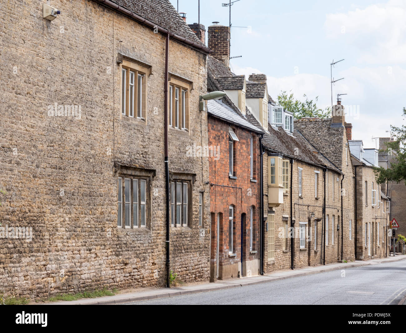 A street lined with old buidlings and houses in the Cotswold town of ...
