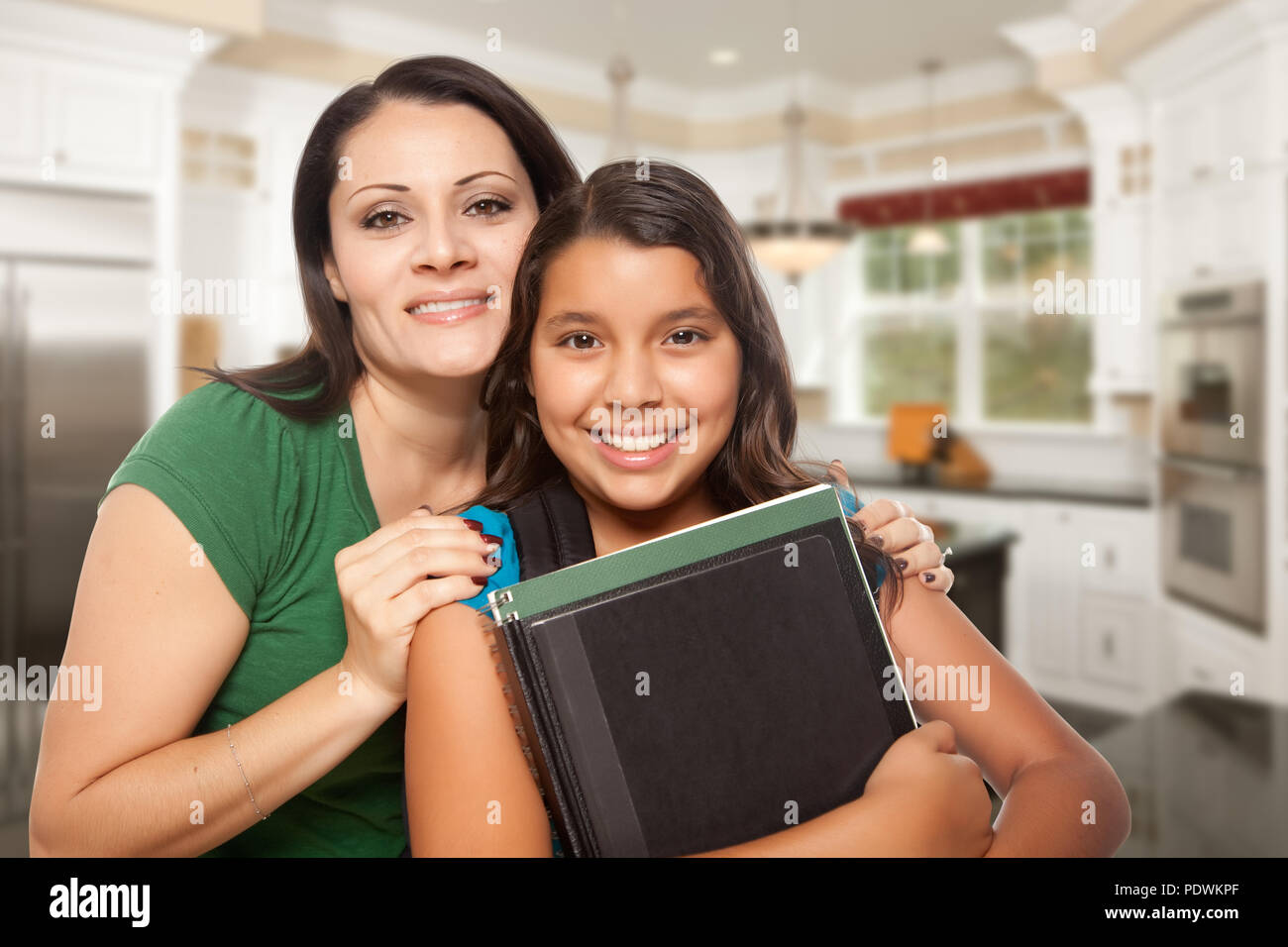 Proud Hispanic Mother and Daughter In Kitchen at Home Ready for School ...