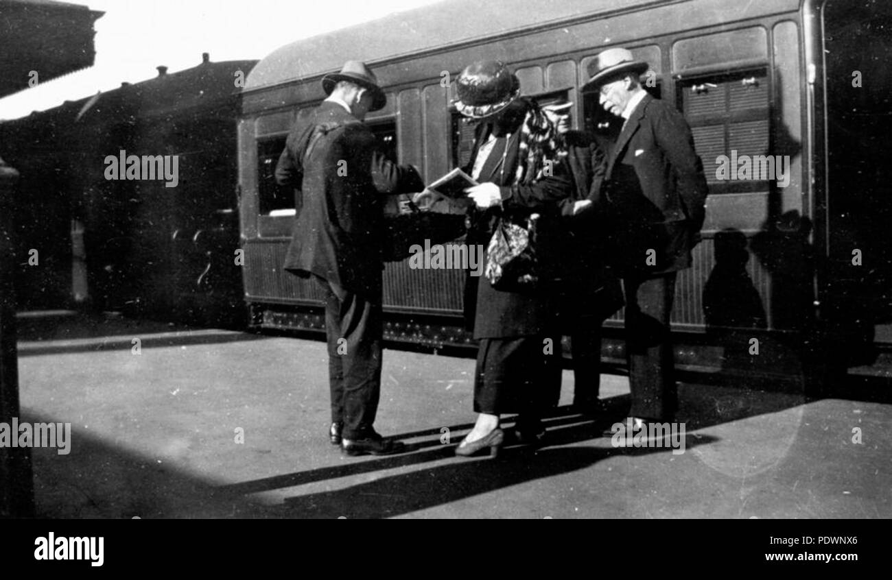 273 StateLibQld 1 78363 Woman making a purchase on a railway platform ...