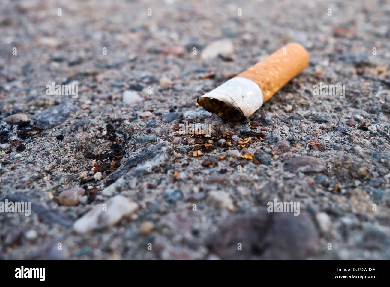 smoked cigarette butt on the ground Stock Photo - Alamy